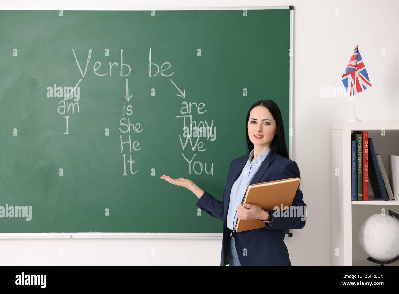 English teacher during lesson near chalkboard in classroom Stock Photo ...