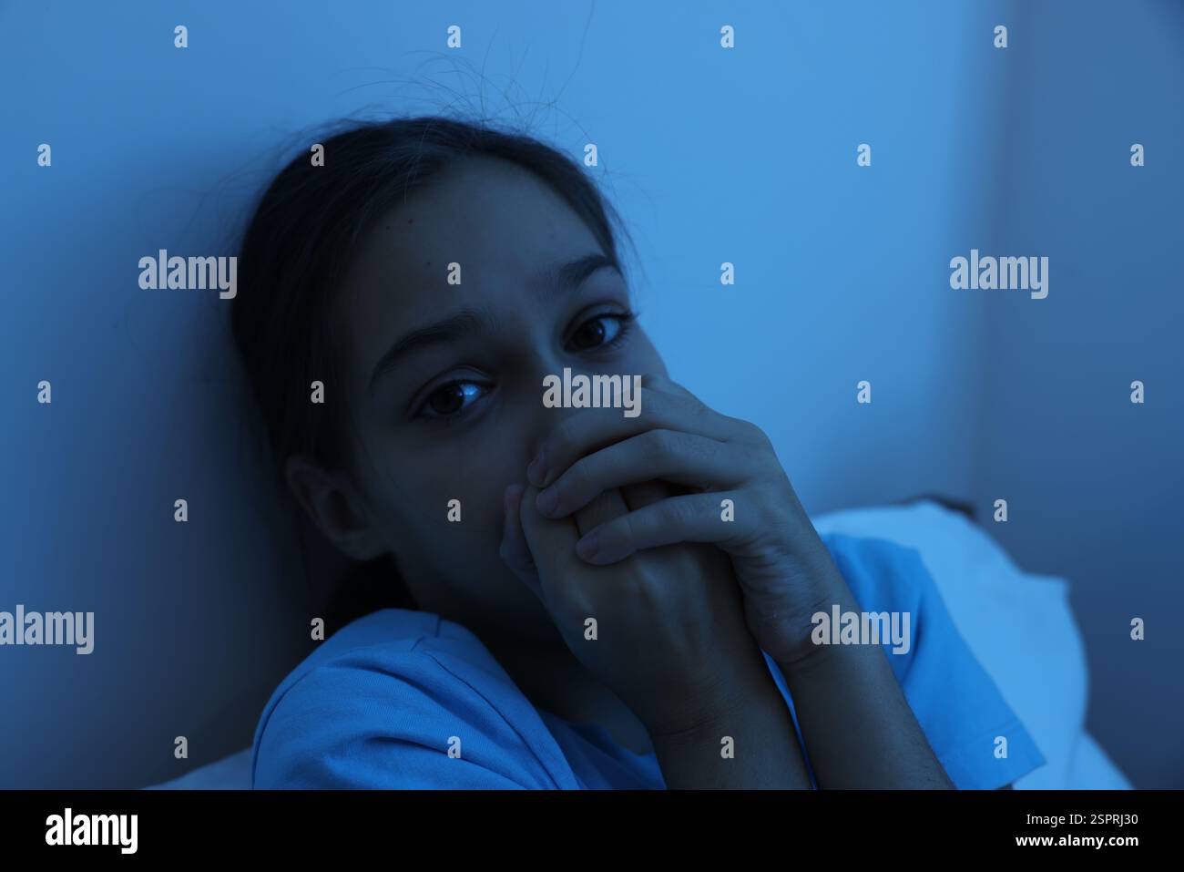 Fearful girl in her bed at night Stock Photo - Alamy