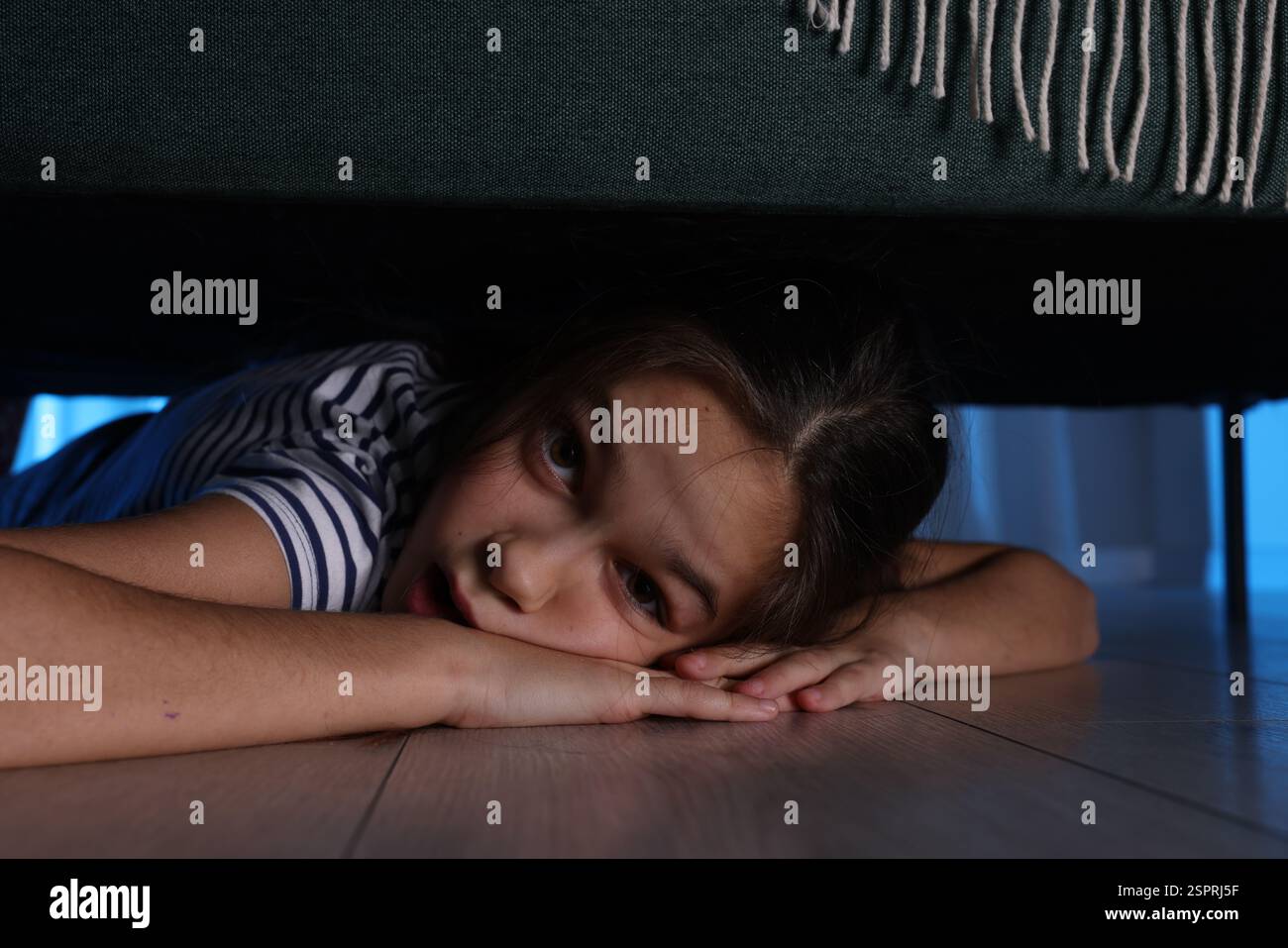 Fearful girl hiding under bed at night Stock Photo - Alamy