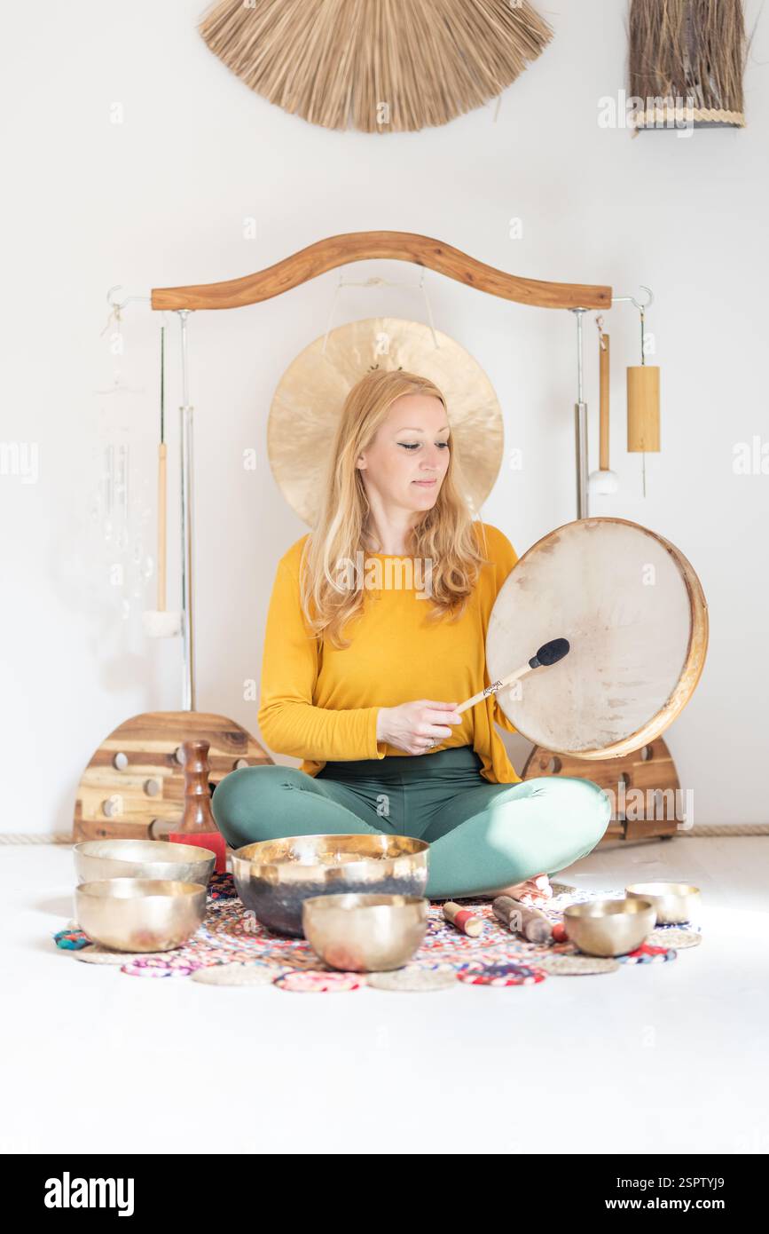 Young cheerful woman performing music therapy session with traditional ...