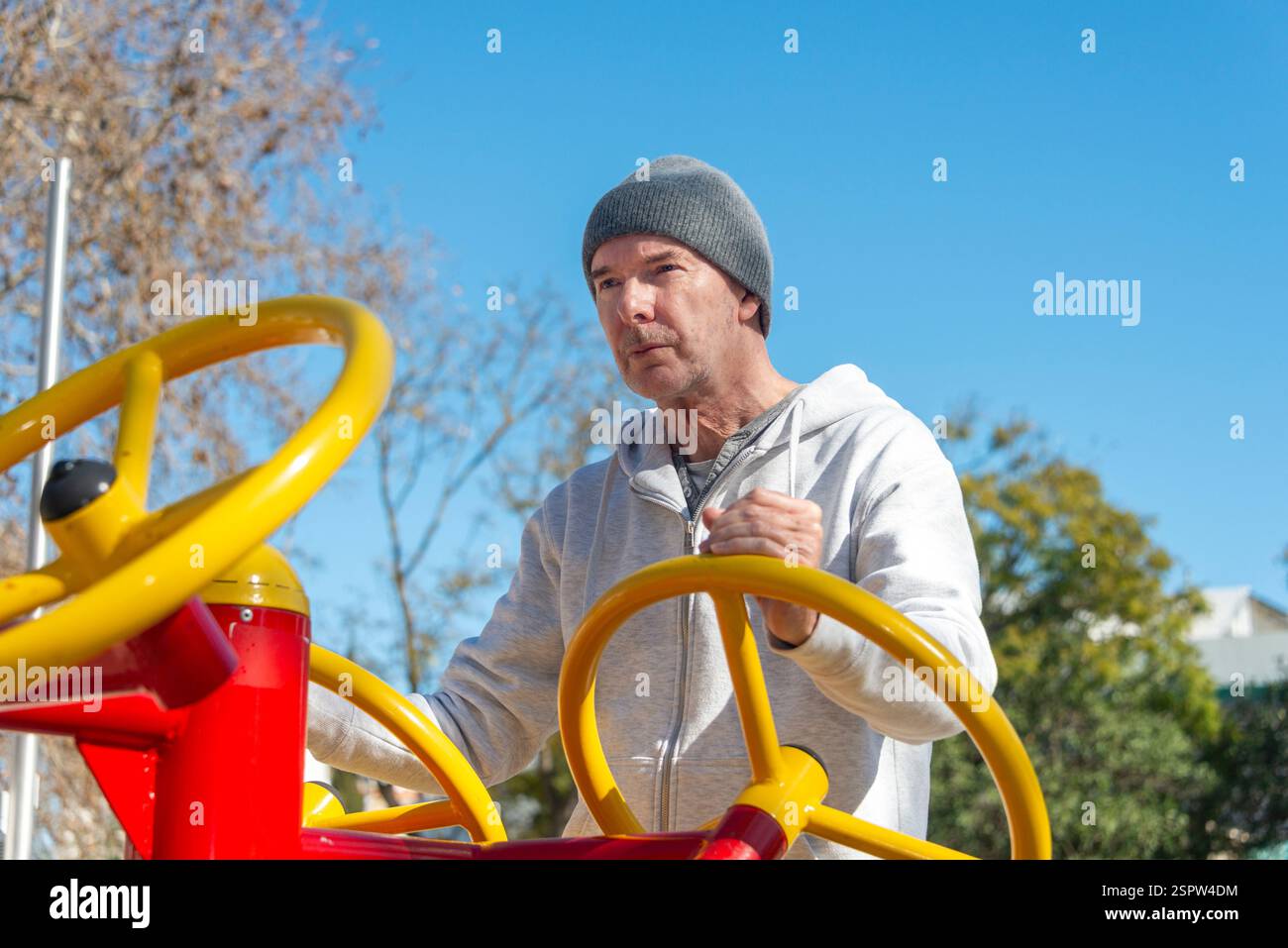 man using an outdoor gym using spinning wheel, Tai Chi exercise Stock ...