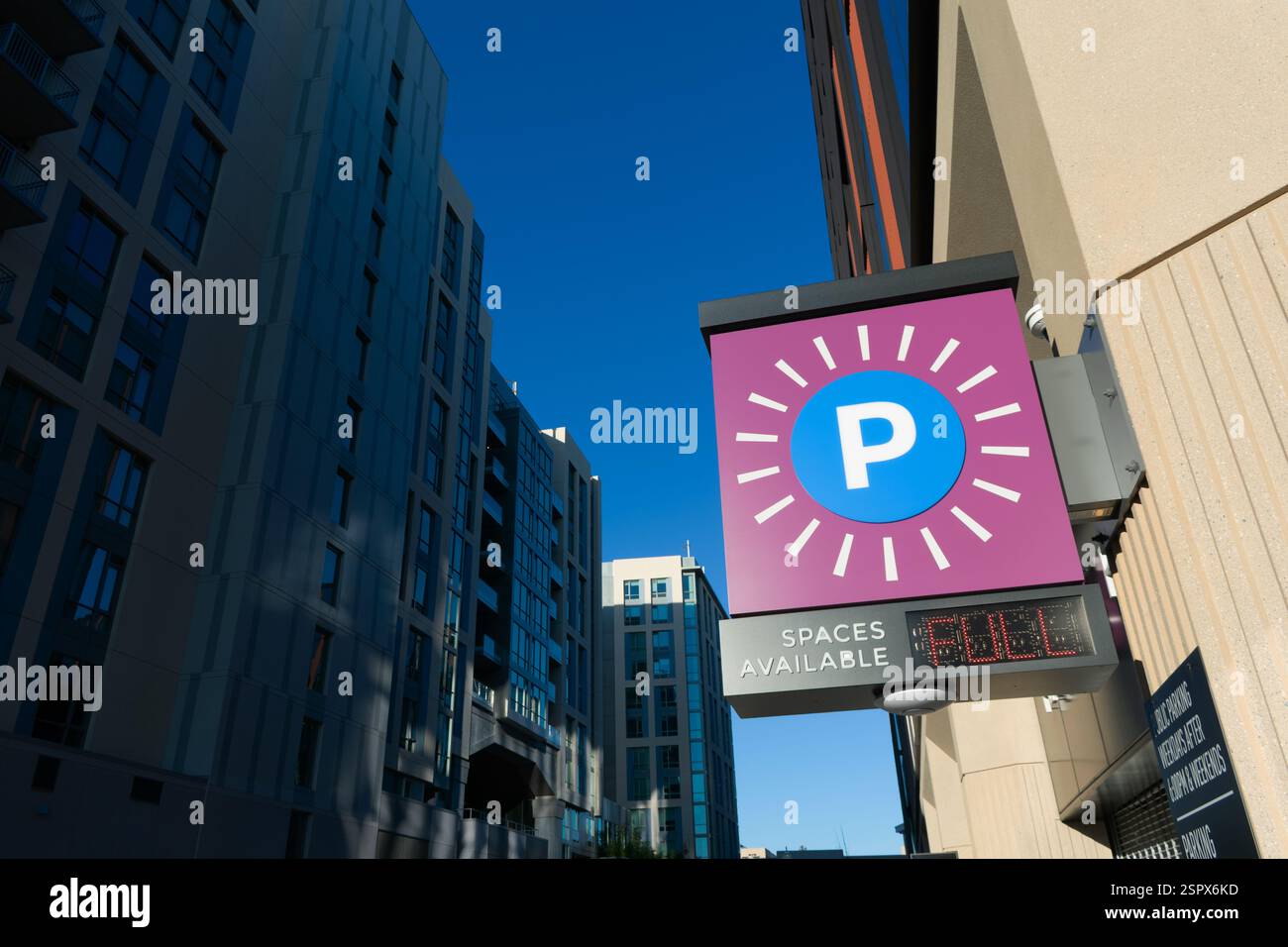 Digital parking signage with purple and blue color scheme against ...