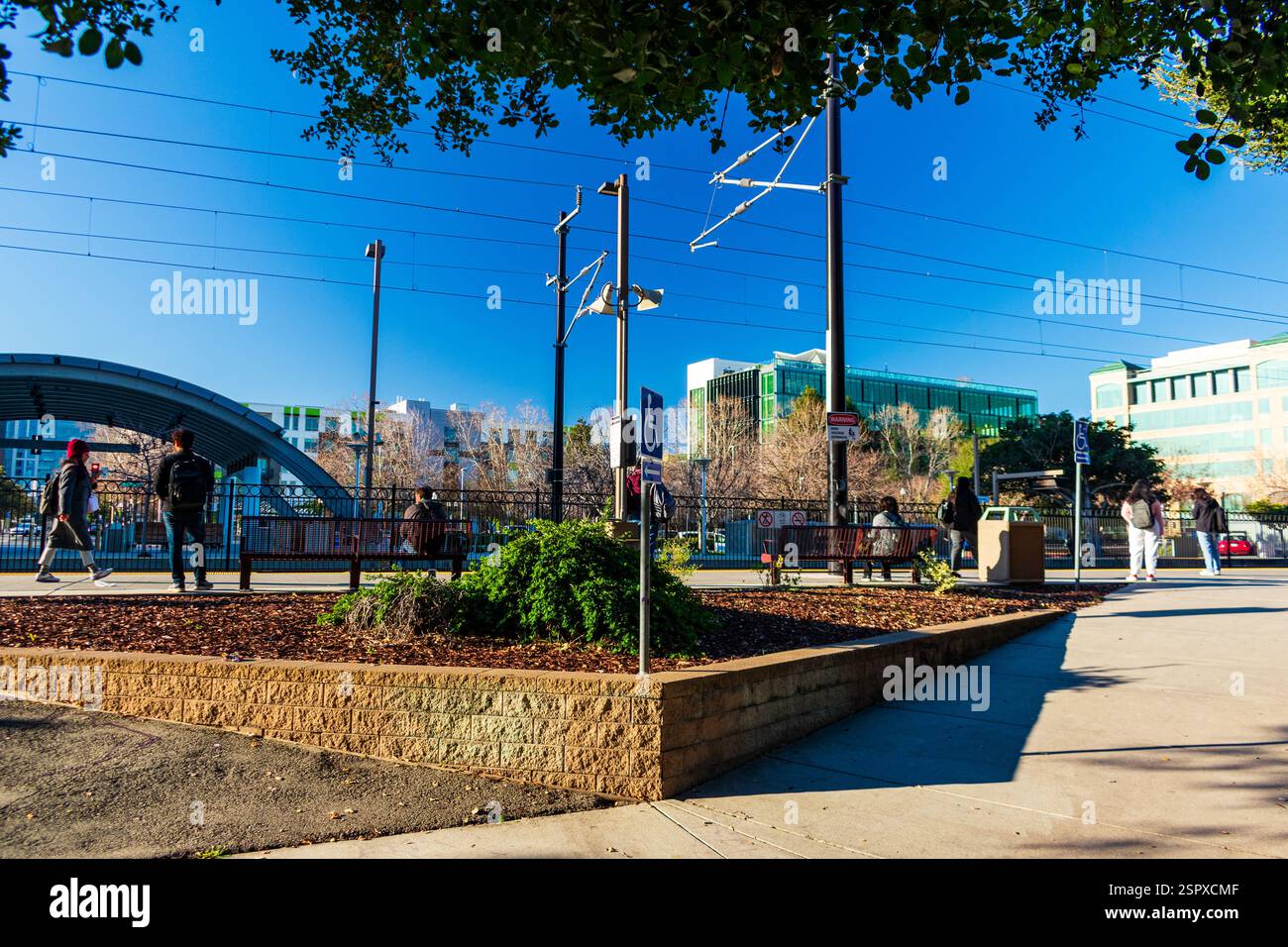 Passengers wait at the Sunnyvale Caltrain station. Modern office ...
