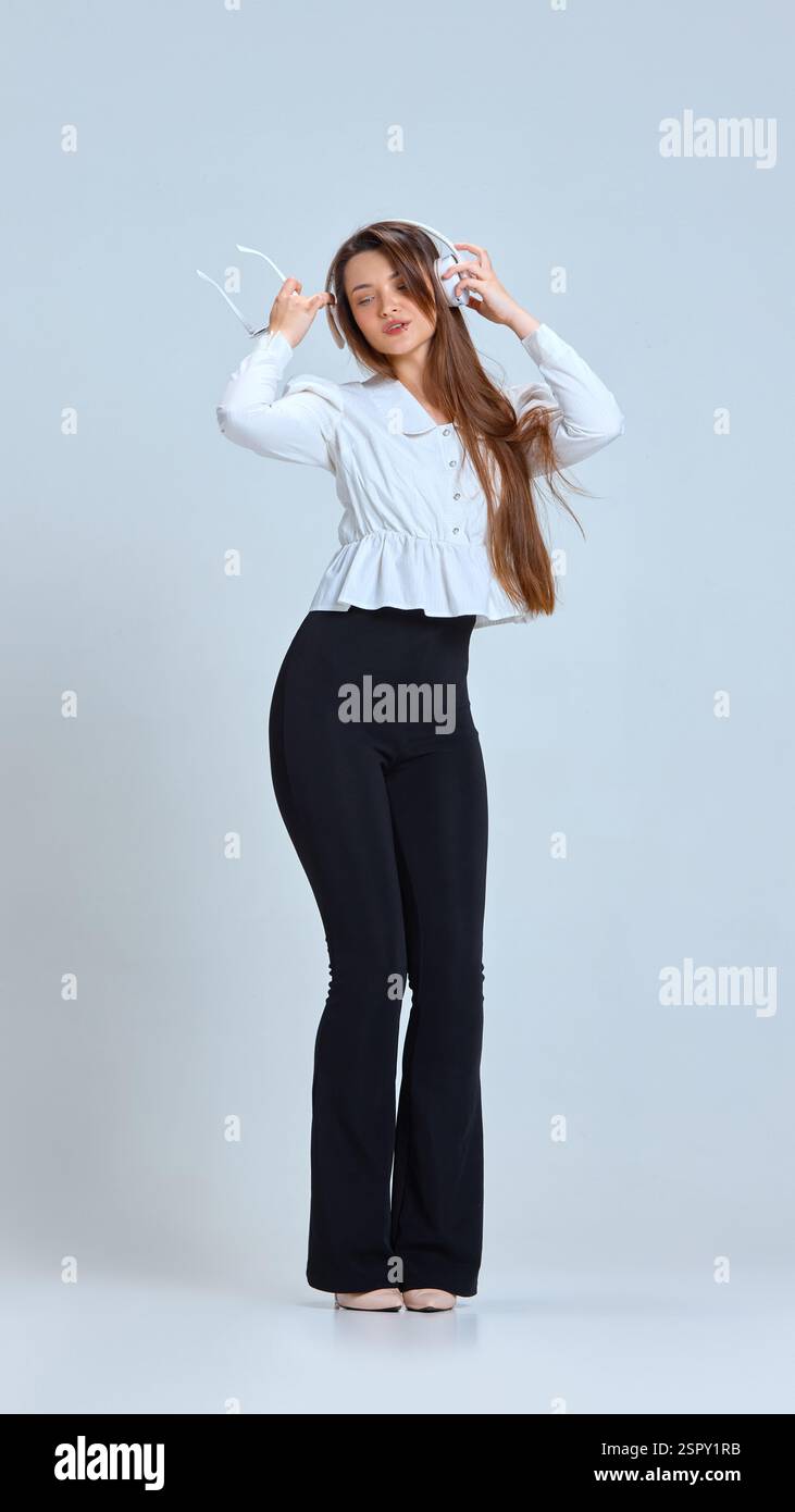 Young woman, with dreamy facial expression, tilting head, eyes closed ...