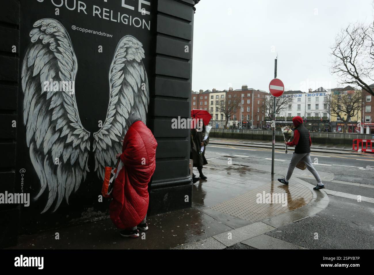 Dublin, Ireland - 14th February 2025 - a homeless woman looks at an art ...