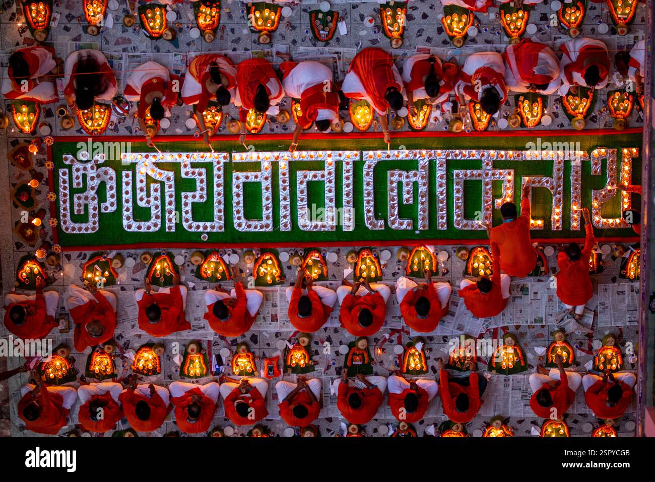 Hindu devotees gather in prayer, lighting oil lamps and burning incense ...