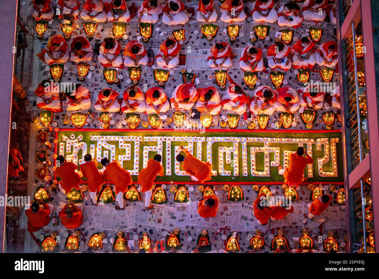 Hindu devotees gather in prayer, lighting oil lamps and burning incense ...