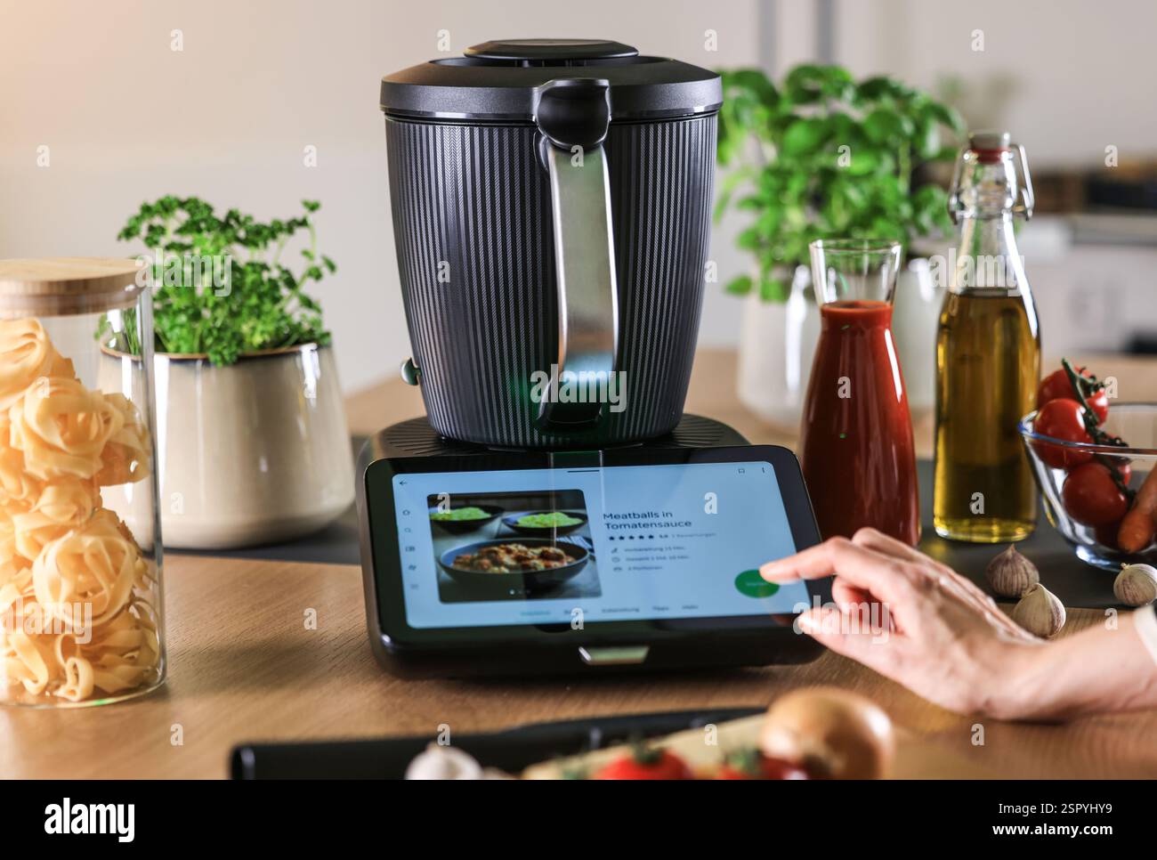 Cologne, Germany. 10th Feb, 2025. A woman operates the new Thermomix ...