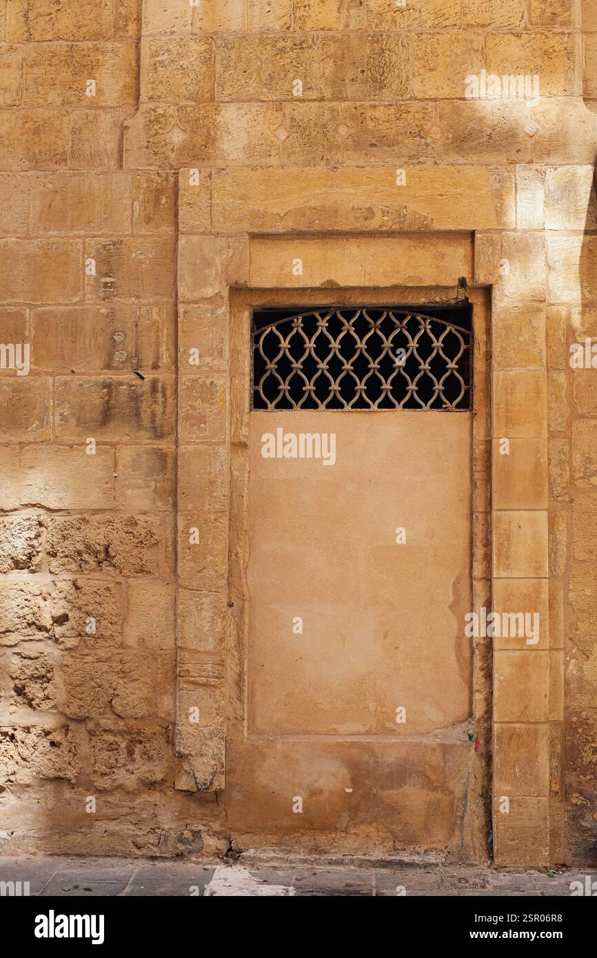 Old sand stone wall with wooden door in Valletta, Malta Stock Photo - Alamy