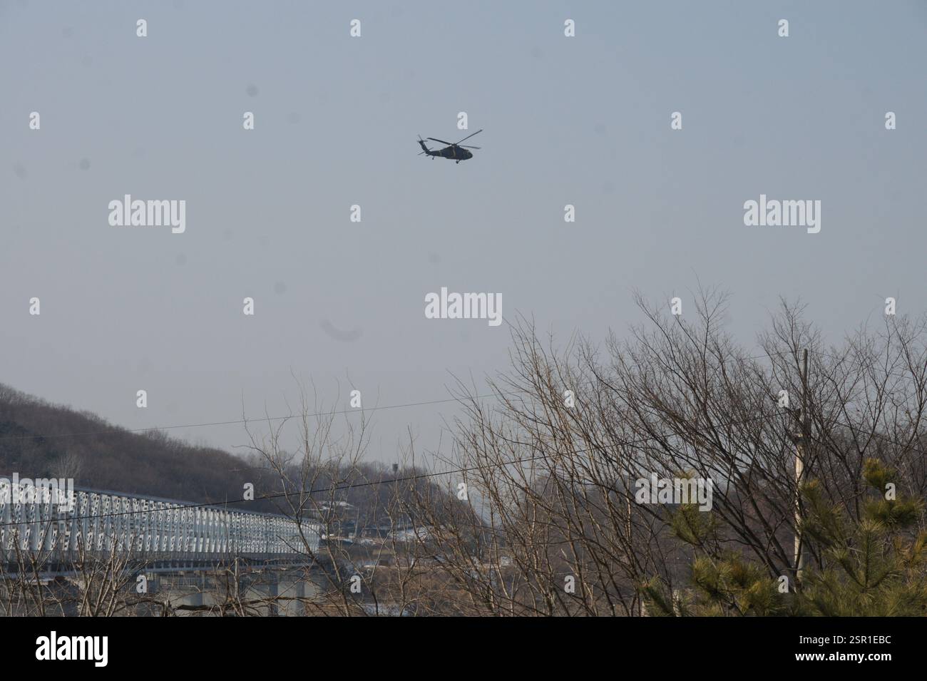 Helicopter South Korea flying over a bridge. The helicopter is black ...