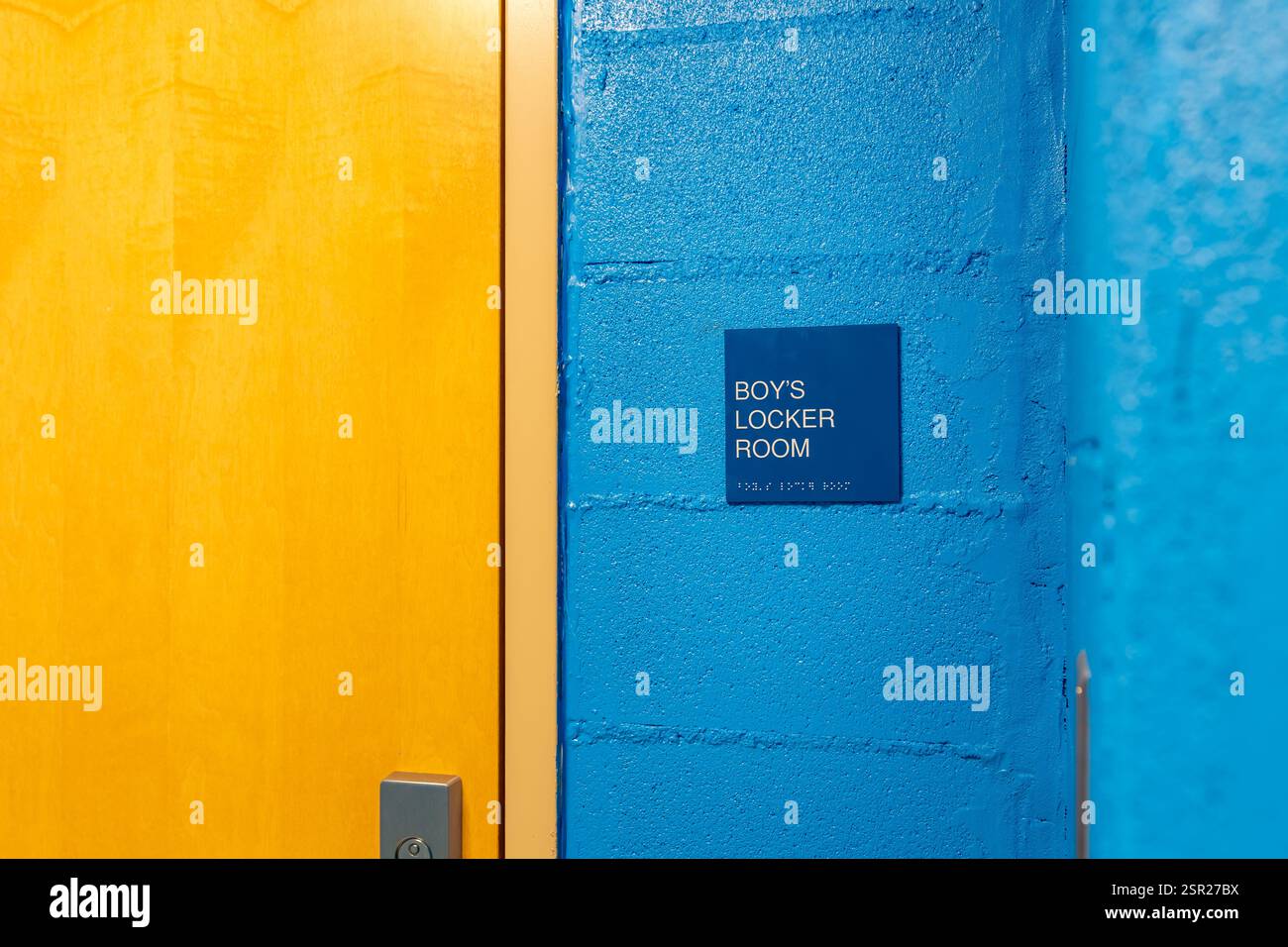 Boy's locker room blue sign mounted on exterior blue wall, next to a ...