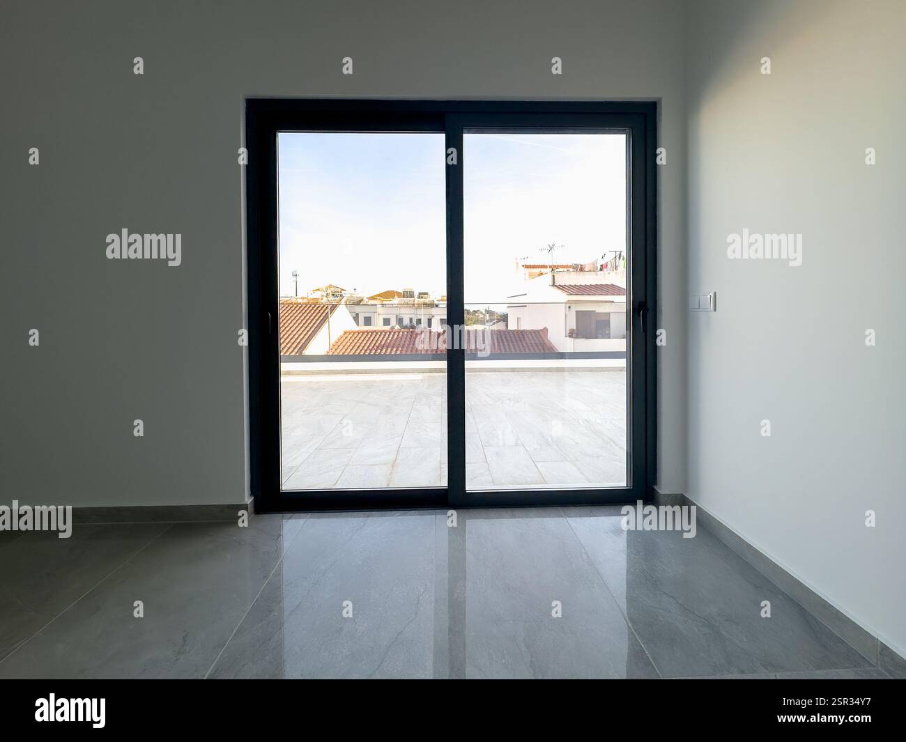 Bright interior space with a black-framed glass door opening to an ...