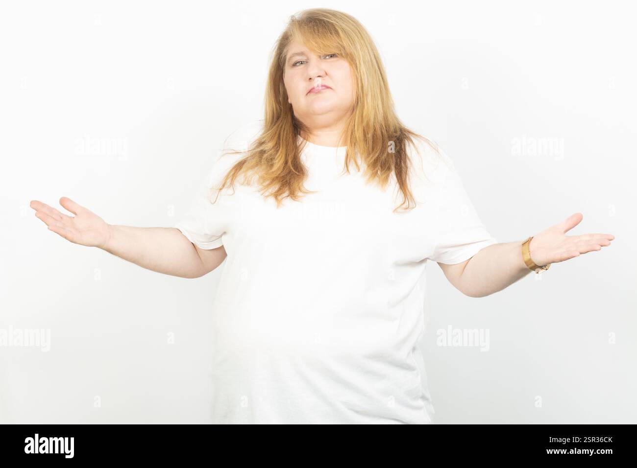 Portrait of a blonde plus size woman shrugging with her arms ...