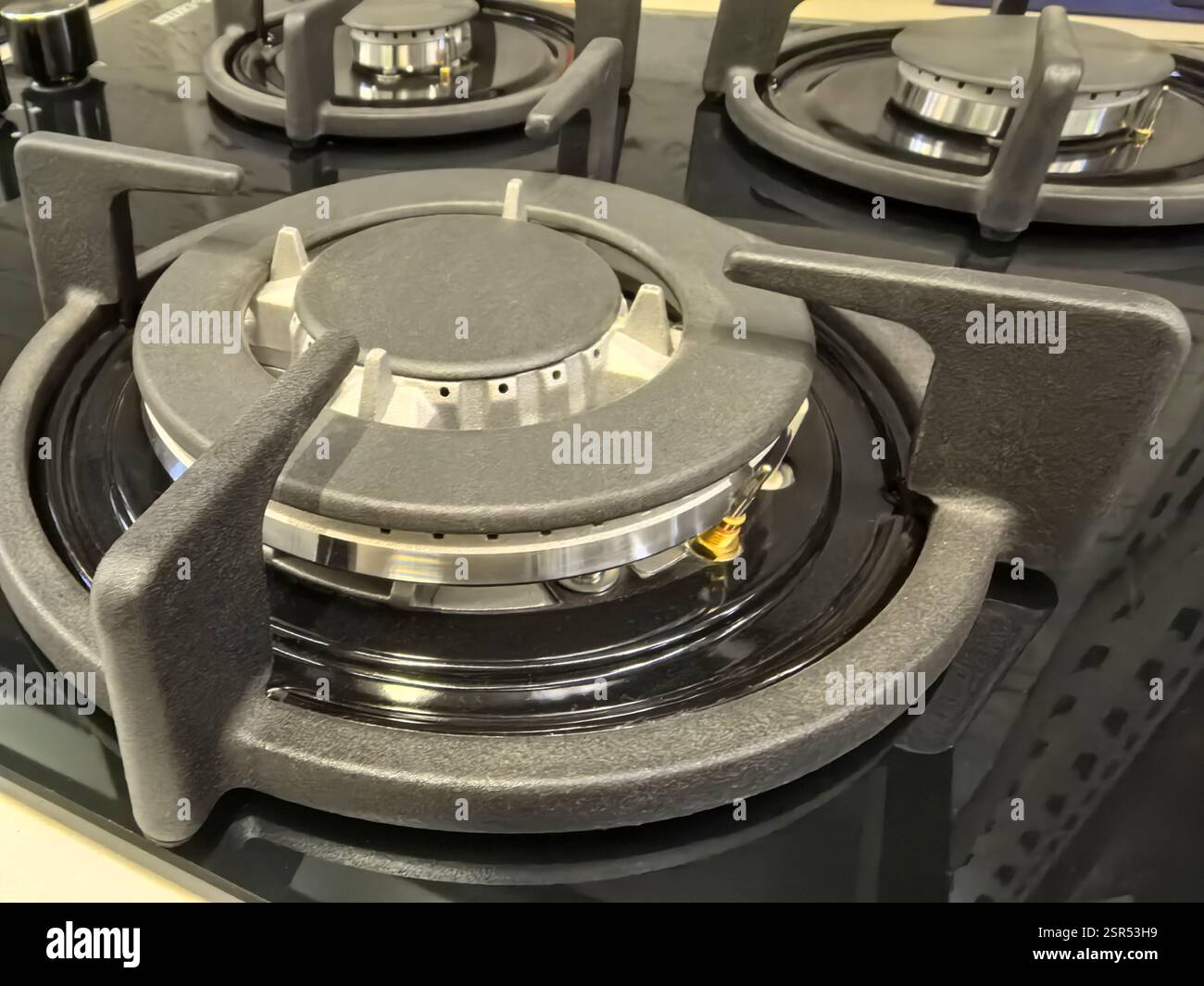 A sleek gas stove burner shines under warm kitchen lighting, showcasing ...