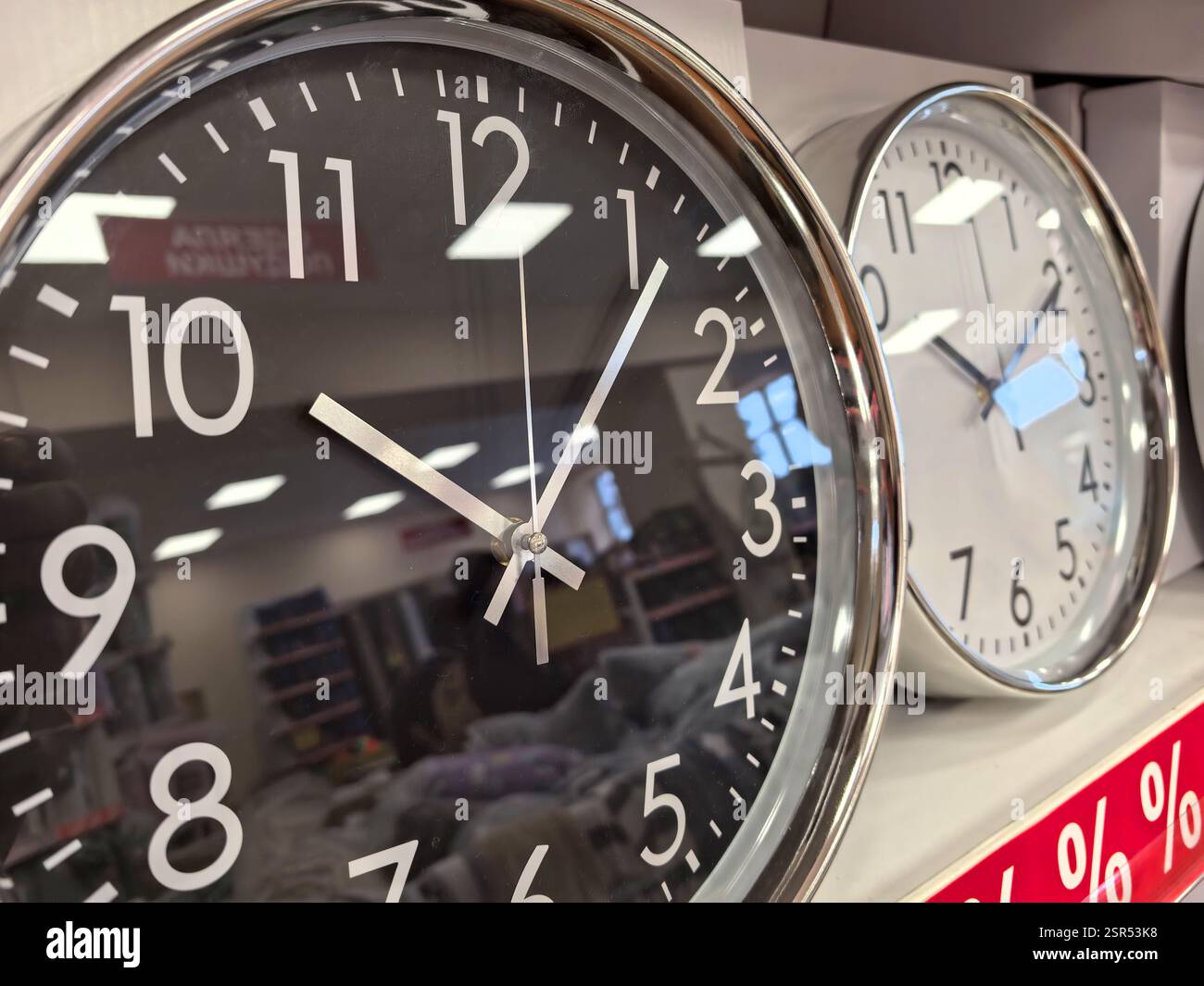 Two sleek wall clocks hang on a display rack, showcasing their elegant ...