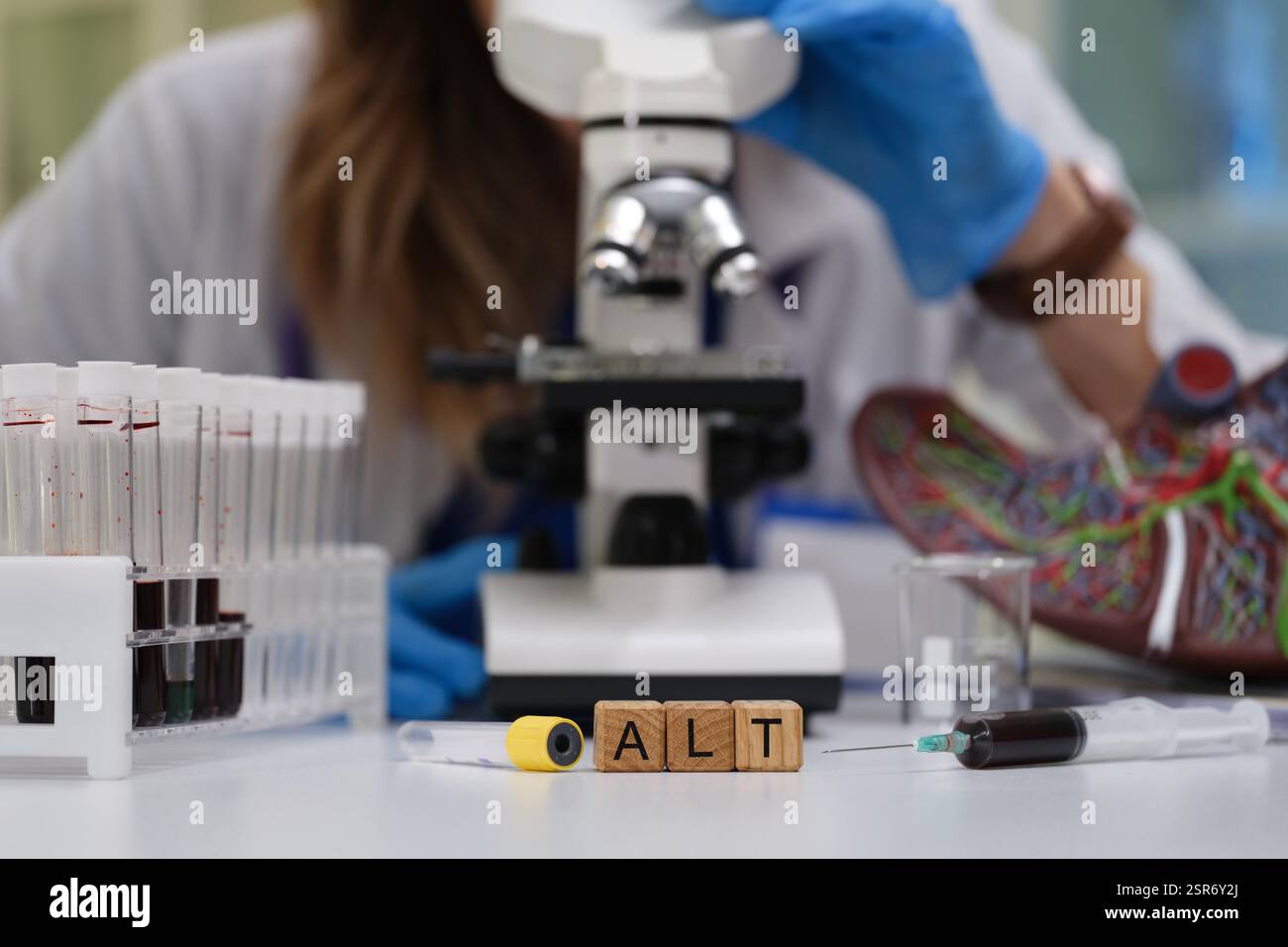 A dedicated researcher meticulously examines blood samples under a ...