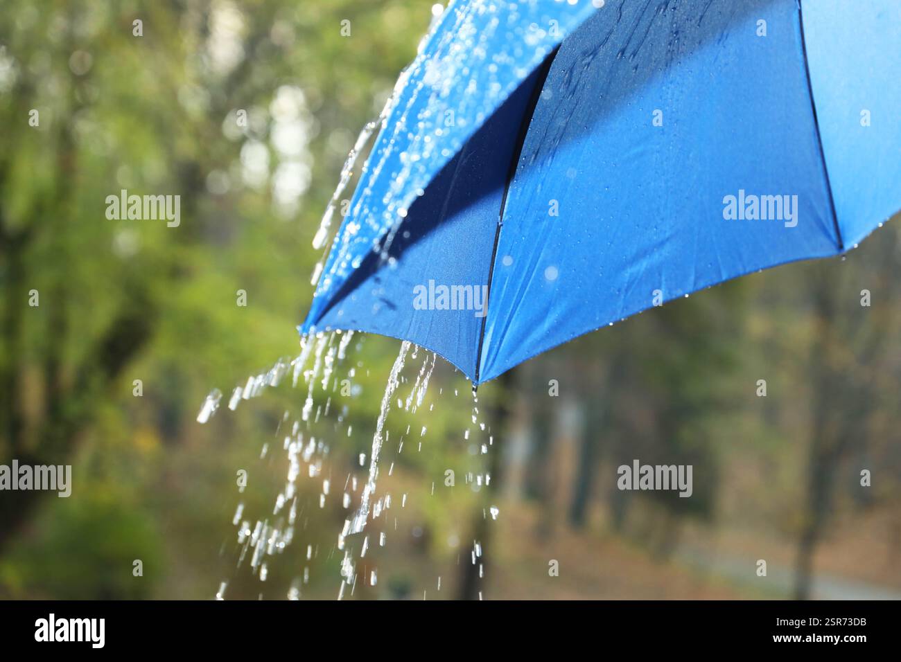 Open blue umbrella under pouring rain outdoors, closeup Stock Photo - Alamy