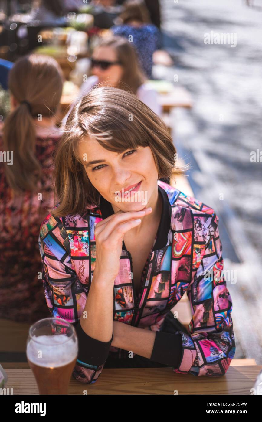Beautiful girl sitting in restaurant with beer. It is a hot summer day ...