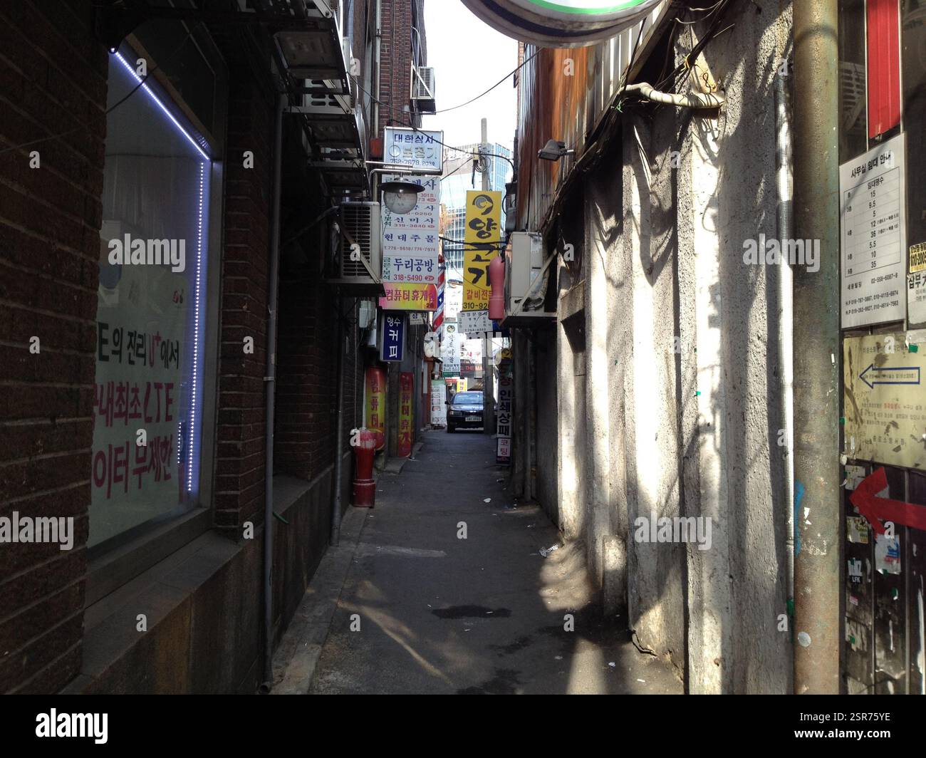 Korean alleyway, narrow street lined with weathered buildings and signs ...