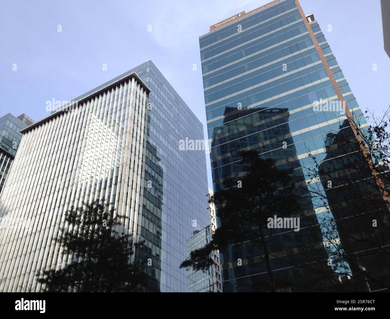 Two skyscrapers in South Korea. Glass facades reflect the sky and ...