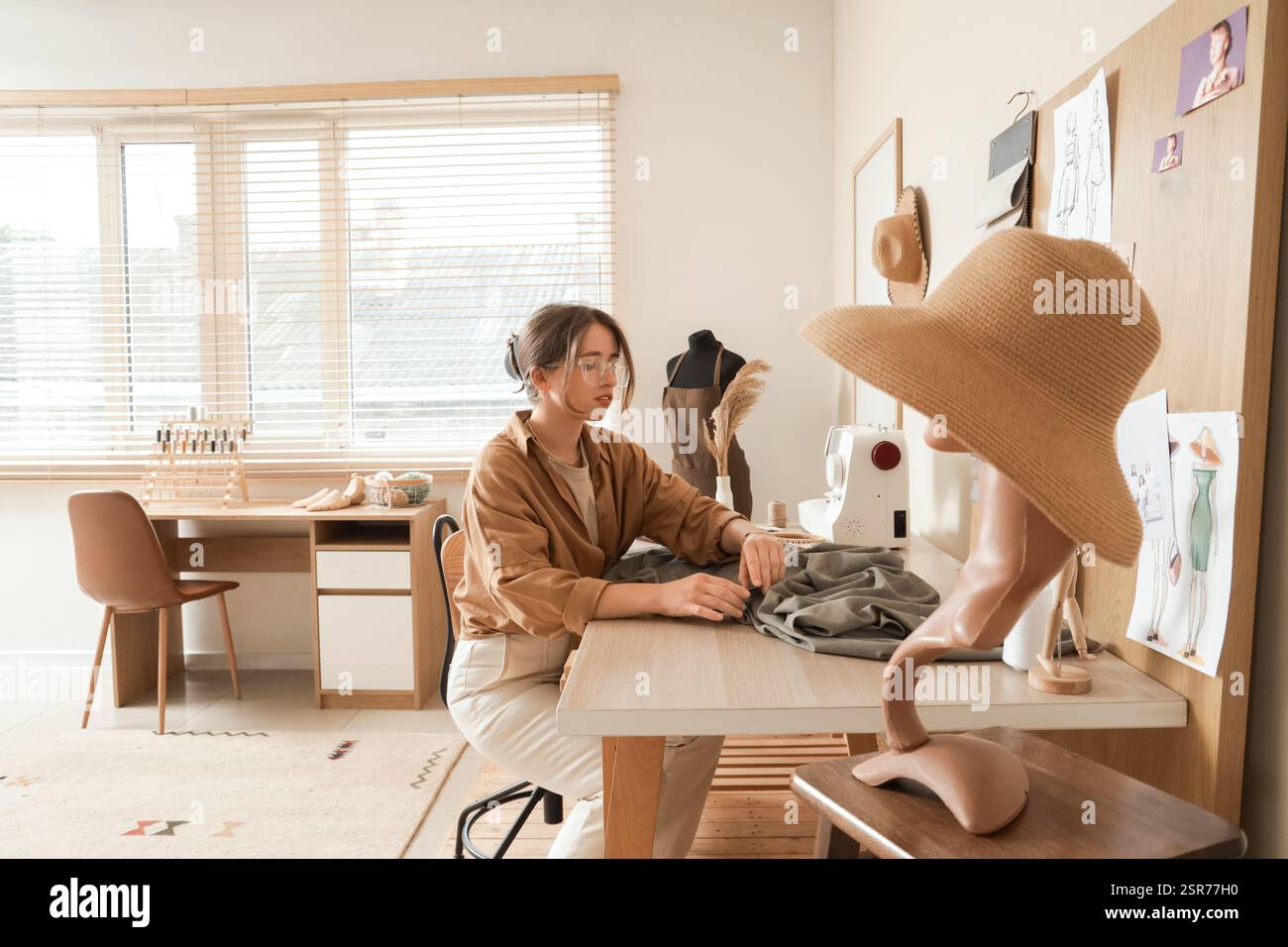 Young female tailor working at her workspace in atelier Stock Photo - Alamy