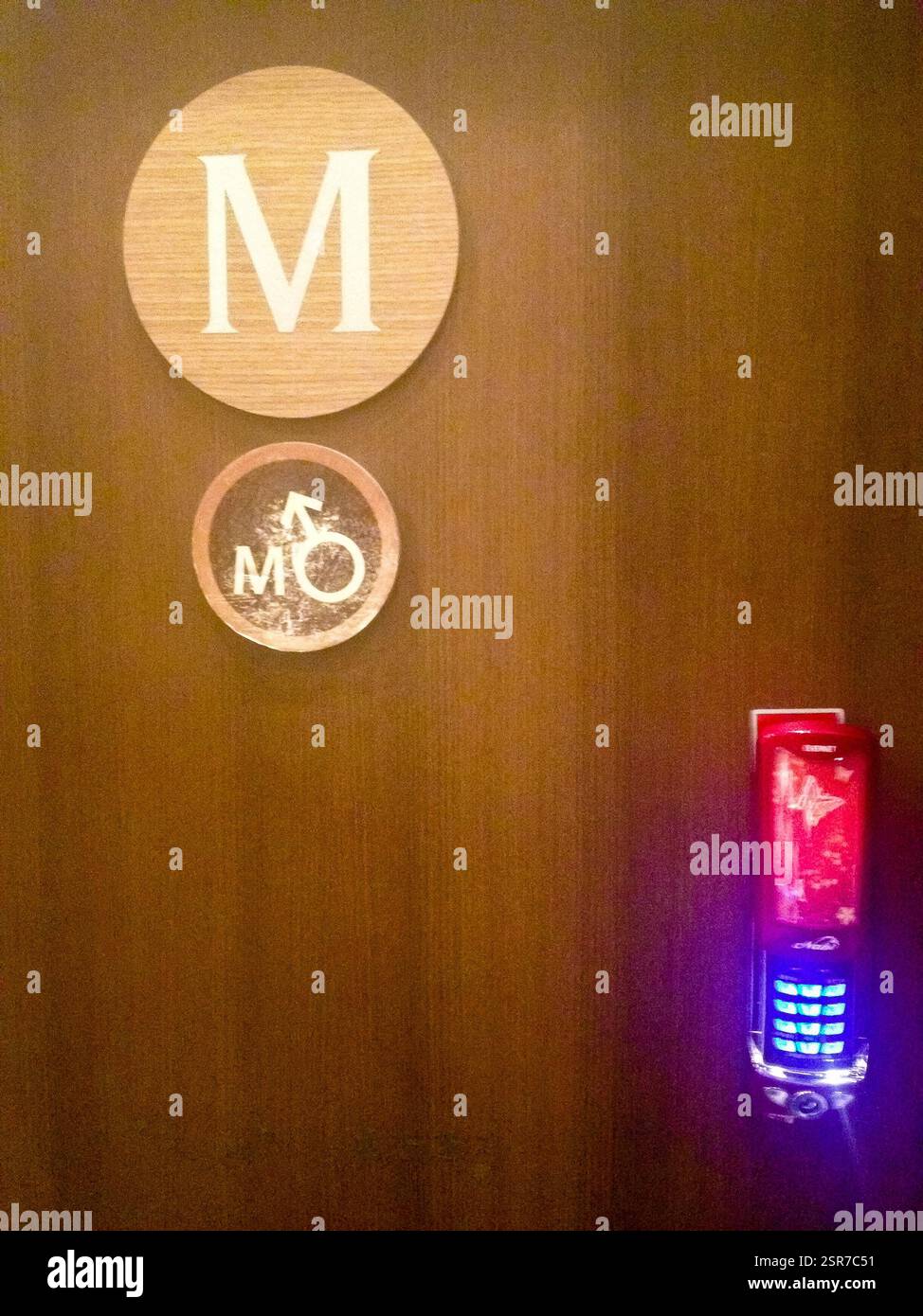 Toilet sign. Circular sign with the letter "M" above a smaller circular ...