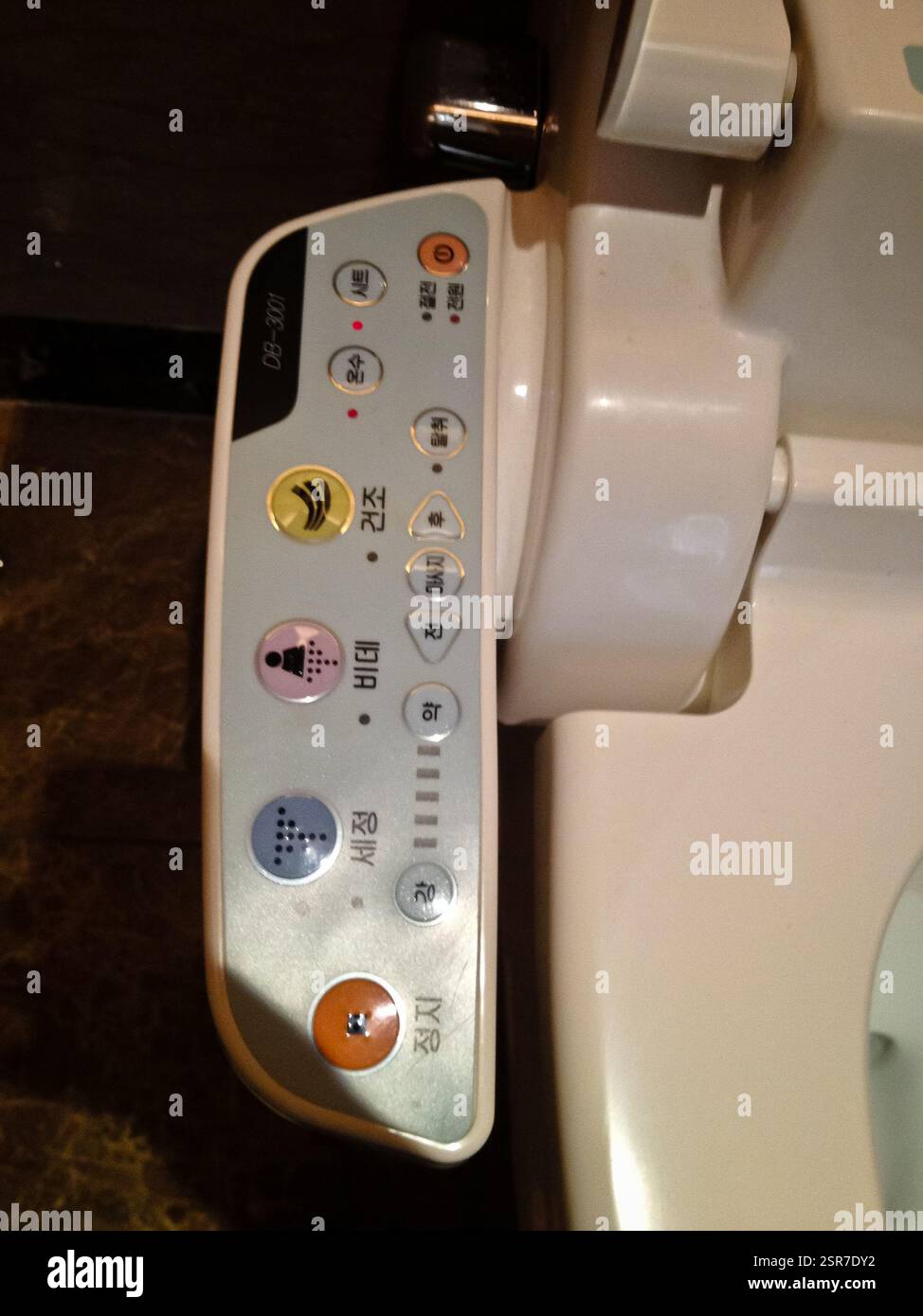 The control panel is made of plastic and is mounted on the wall. The buttons are labeled with ...