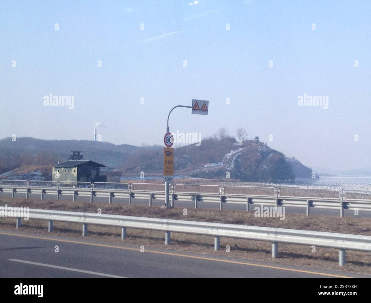 Highway with speed limit sign. Mountains in the distance. Cold weather ...