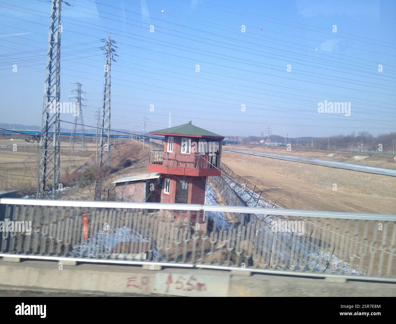 Guardhouse, a red structure with an observation deck. Barbed wire fence ...
