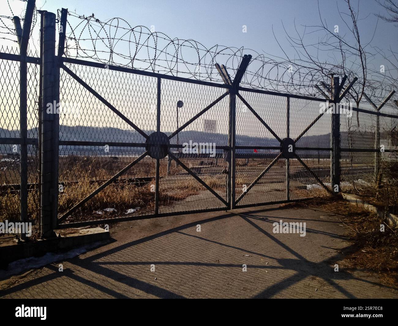 Fenced gate, barbed wire, rusty metal. Symbol of division, separation ...