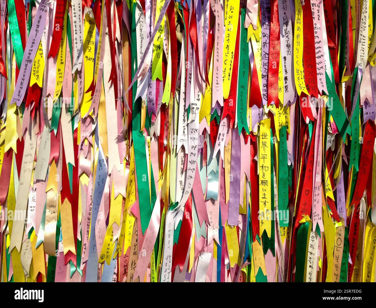 Colorful ribbons with written messages hang from a string. Many ...