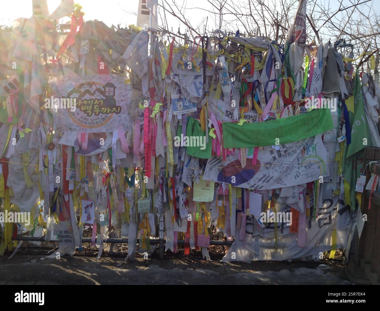 Fence adorned with colorful ribbons, posters, and flags. Messages of ...