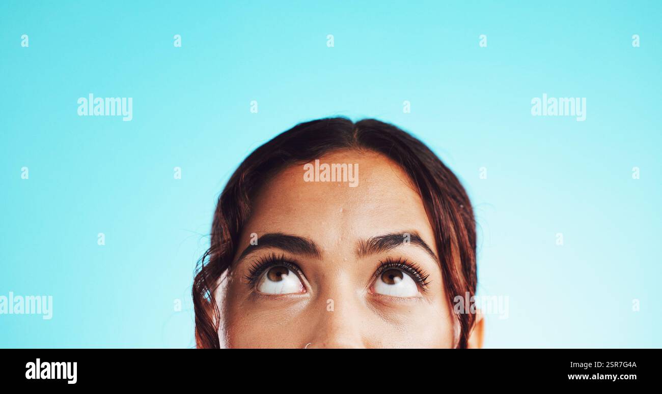 Closeup, eyes and woman in studio, thinking and problem solving on blue ...