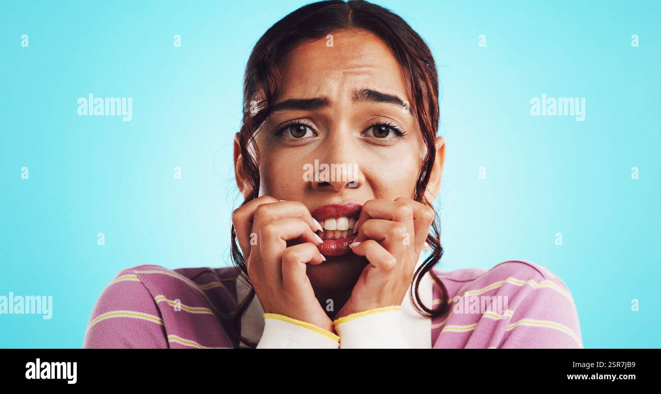Woman, portrait and biting nails with anxiety in studio for worry, fear or panic with pressure ...