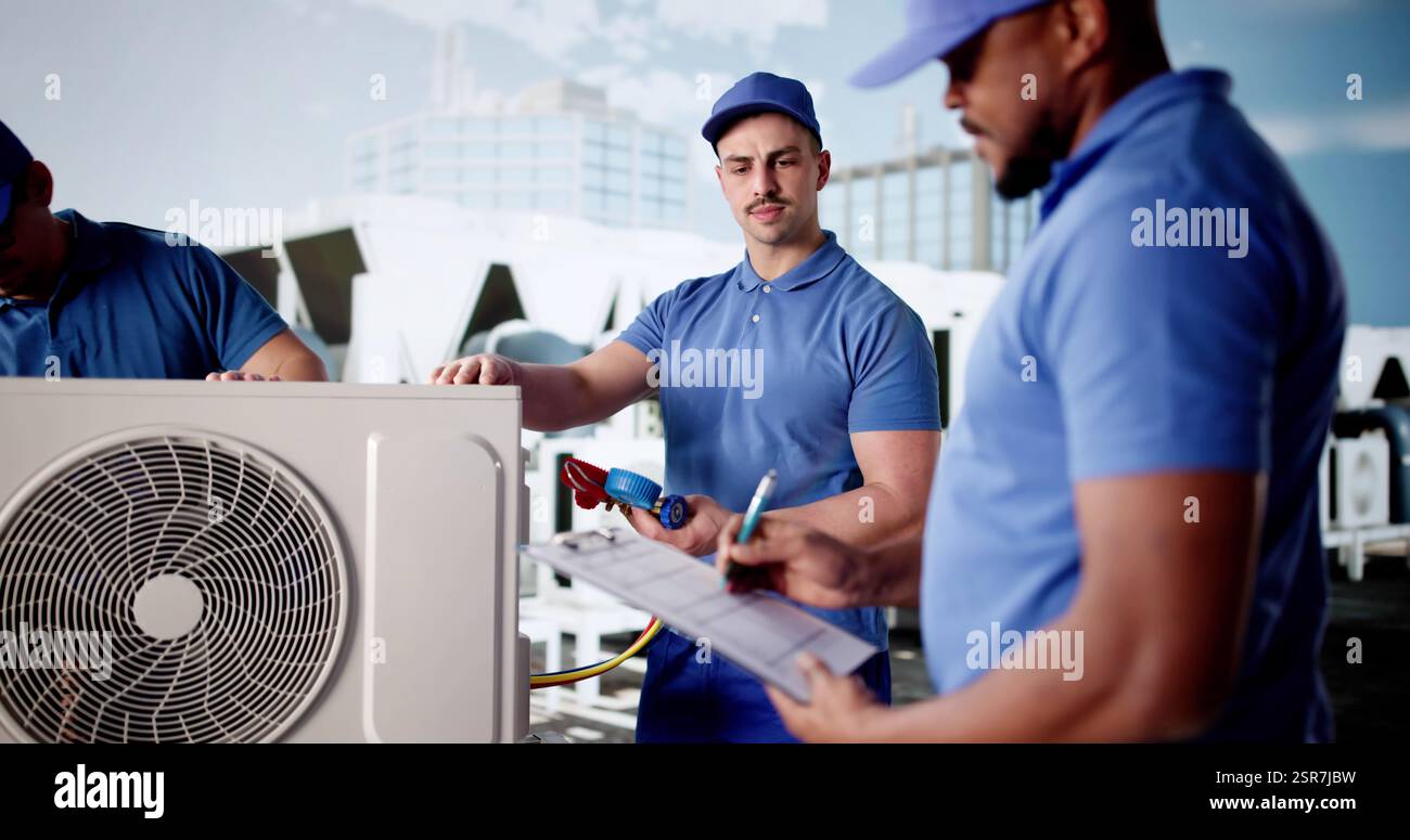Diverse group of workers install air conditioner in commercial building ...
