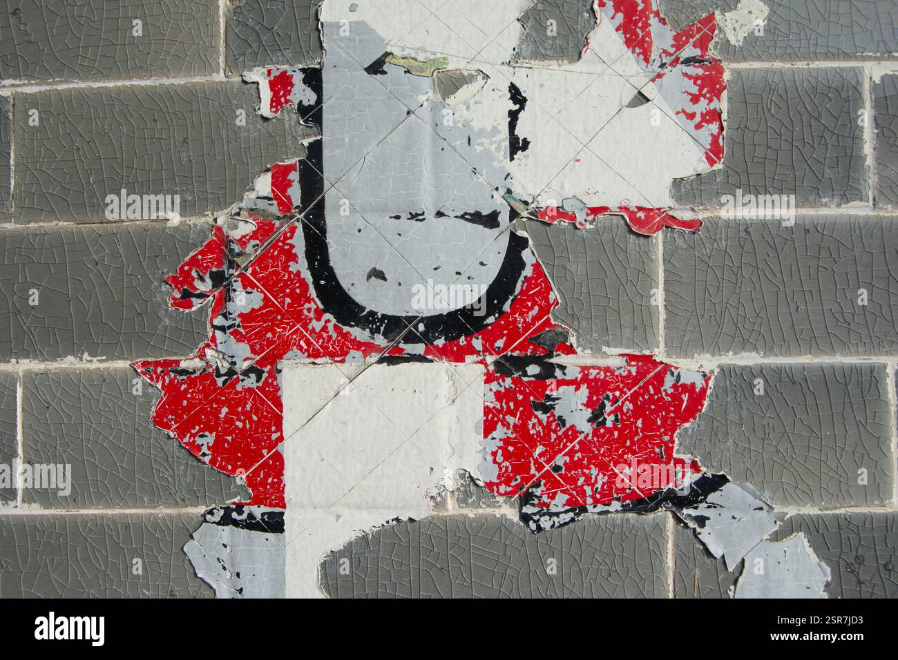 Texture and contrast, a worn out sign fragment against a cracked tile ...