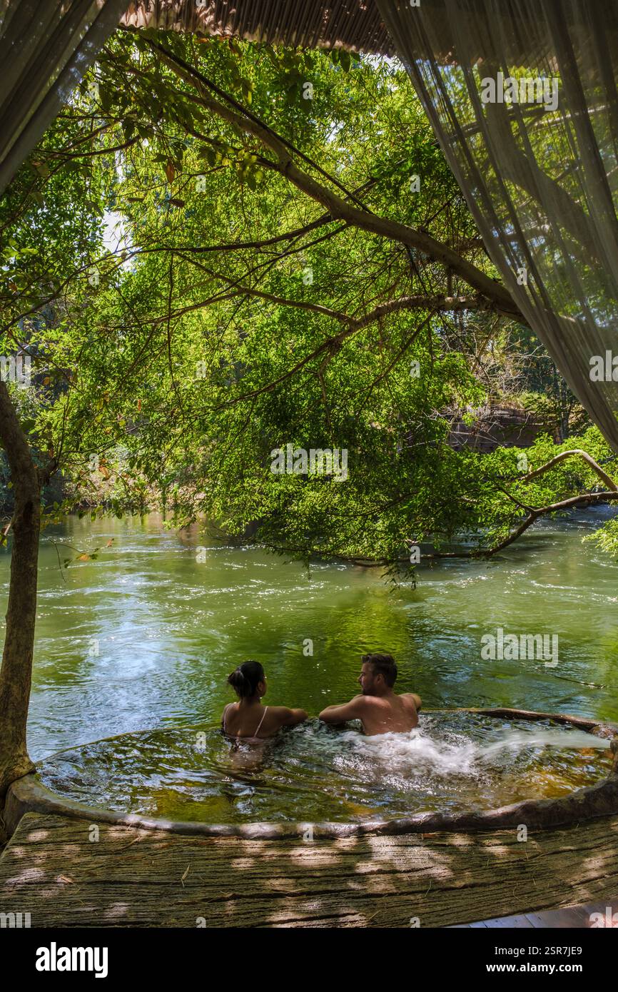 Amidst lush greenery, a couple enjoys tranquil waters in a secluded ...