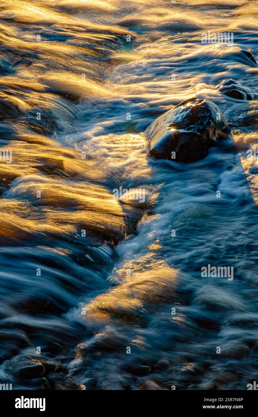Sunset light skims over the rushing water of Hurricane River as it ...