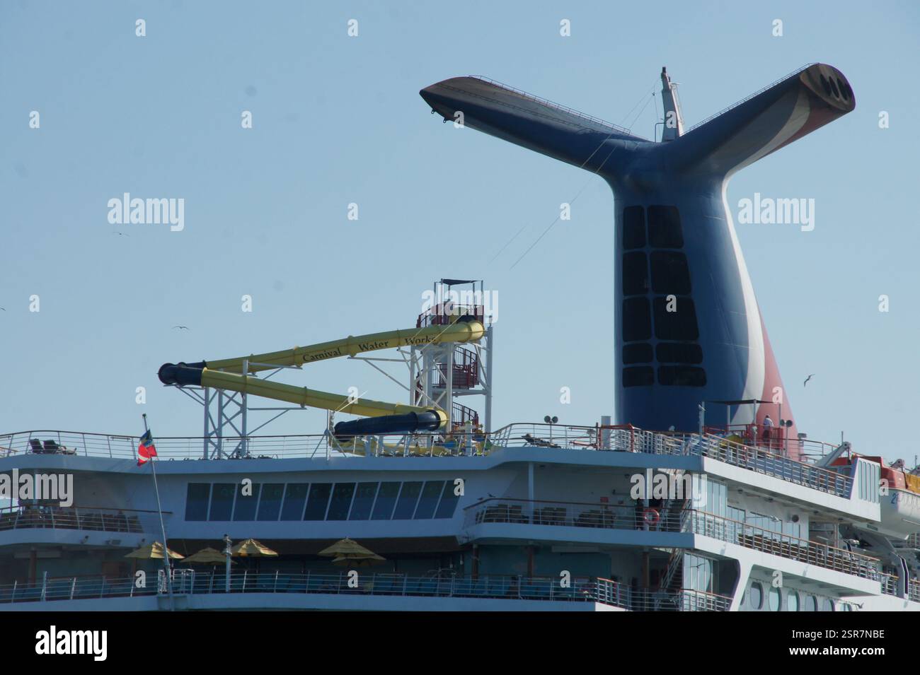 Cruise ship funnel boasts distinct yellow, blue, and red colors. Water ...