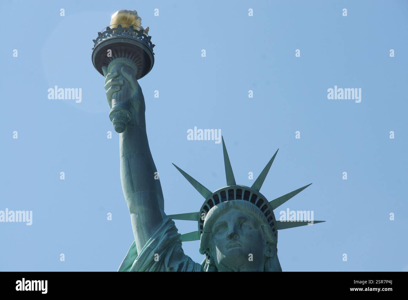 A close-up of Lady Liberty's face in New York, sunlight warms her cheek ...