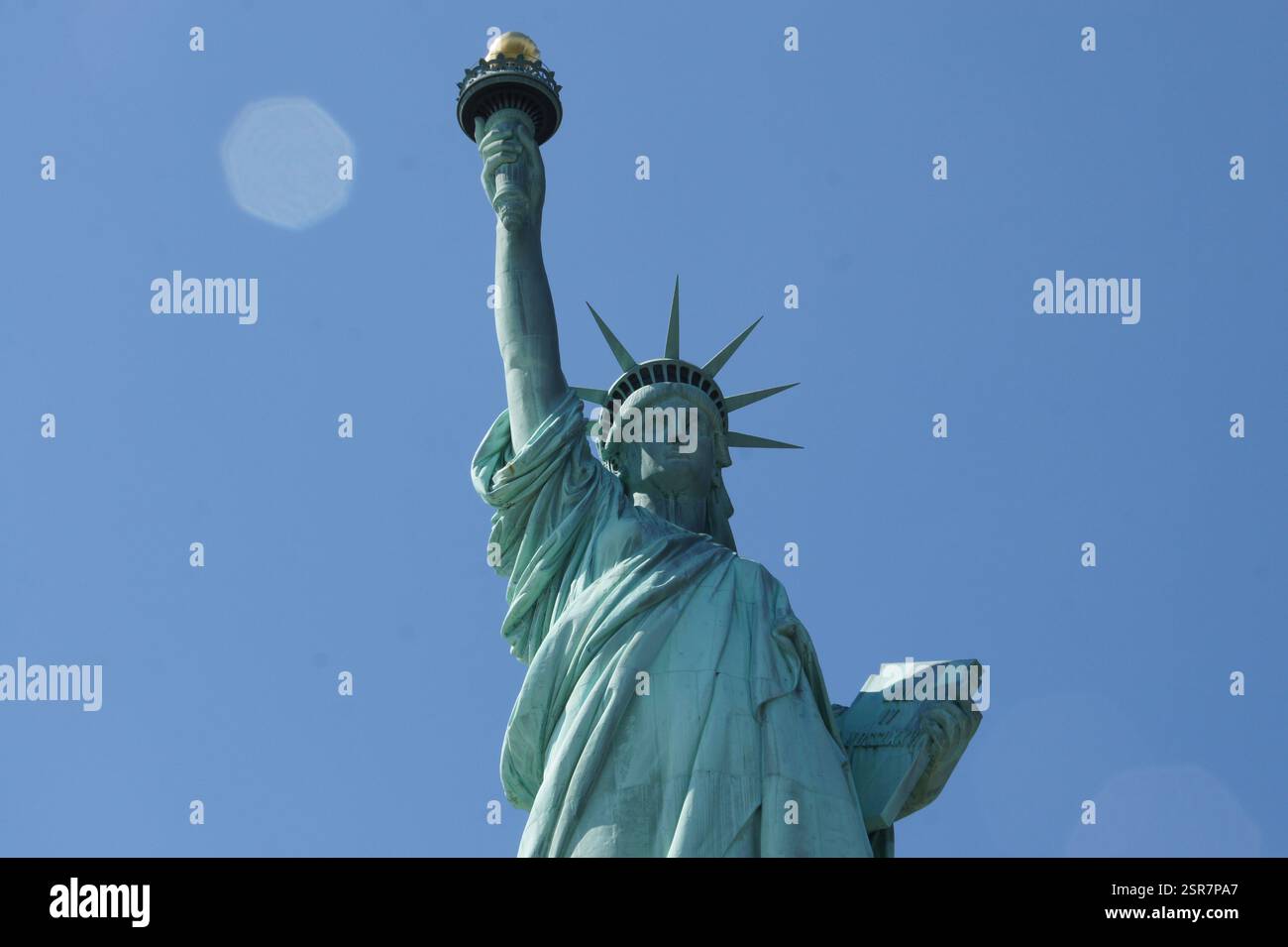 A close-up reveals the weathered green patina of the Statue of Liberty ...
