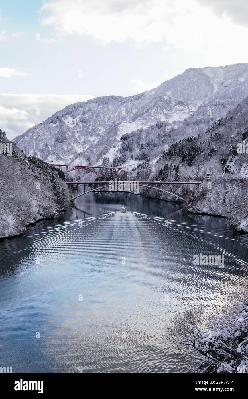 A scenic boat cruise on the Shogawa River in winter, surrounded by snow ...