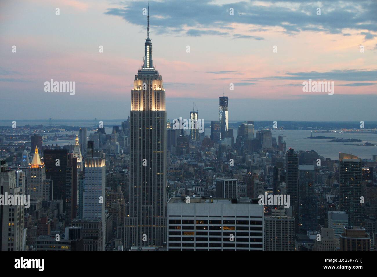 New York City at dusk. The Empire State Building, a luminous beacon ...