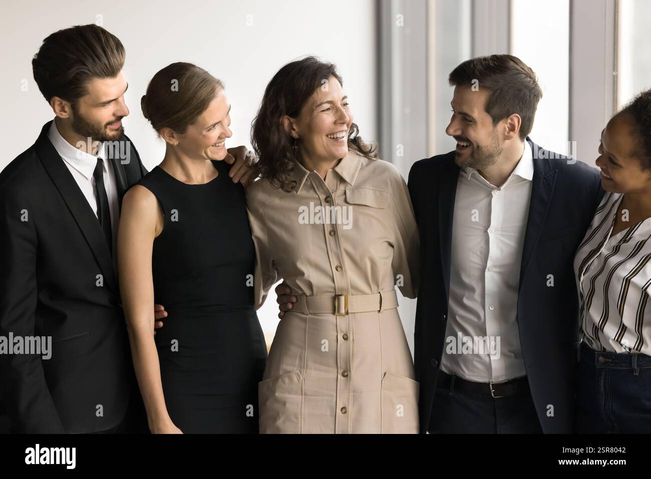 Five business colleagues hugging, stand together in office Stock Photo ...