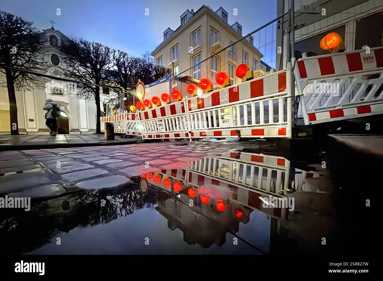 Beleuchtete Baustelle auf einer Strasse mit Kopfsteinpflaster.Sperrung ...