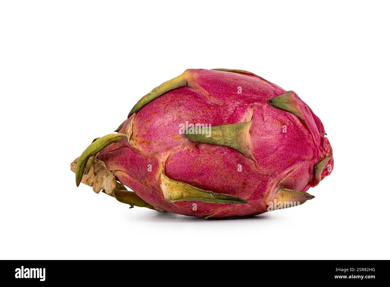 Vibrant whole red pitaya with unique skin texture and green leaves ...