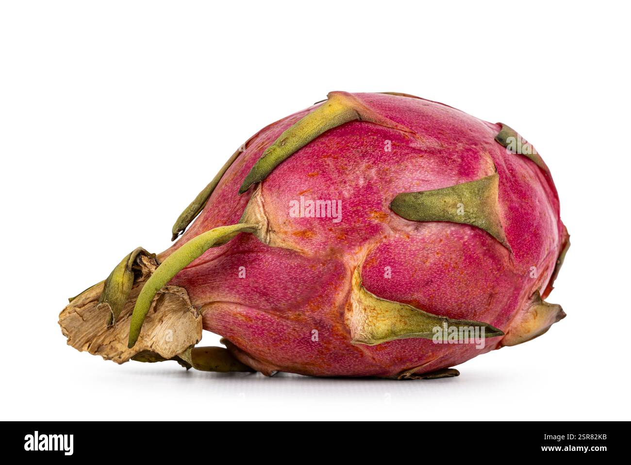 Vibrant whole red pitaya with unique skin texture and green leaves ...