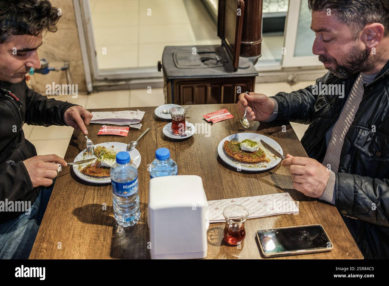People eating kunafa at a table. Kunafa, at famous dessert of the ...