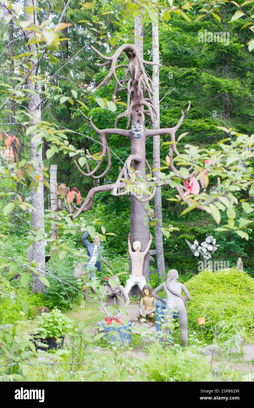 A surreal tree-like sculpture surrounded by human-like figures at ...