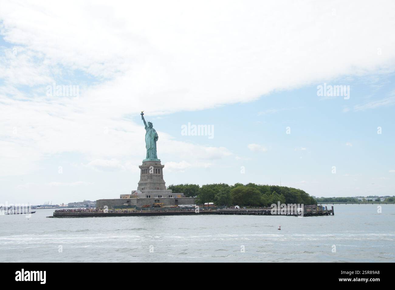 A ferry in New York Harbor glides past the colossal Statue of Liberty ...